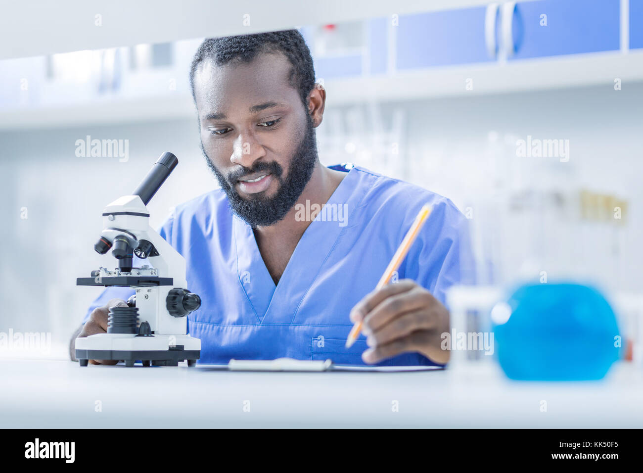 Joyful smart man writing Stock Photo - Alamy