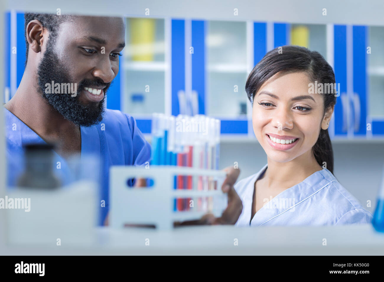 Nice joyful colleagues looking at the test tubes Stock Photo - Alamy