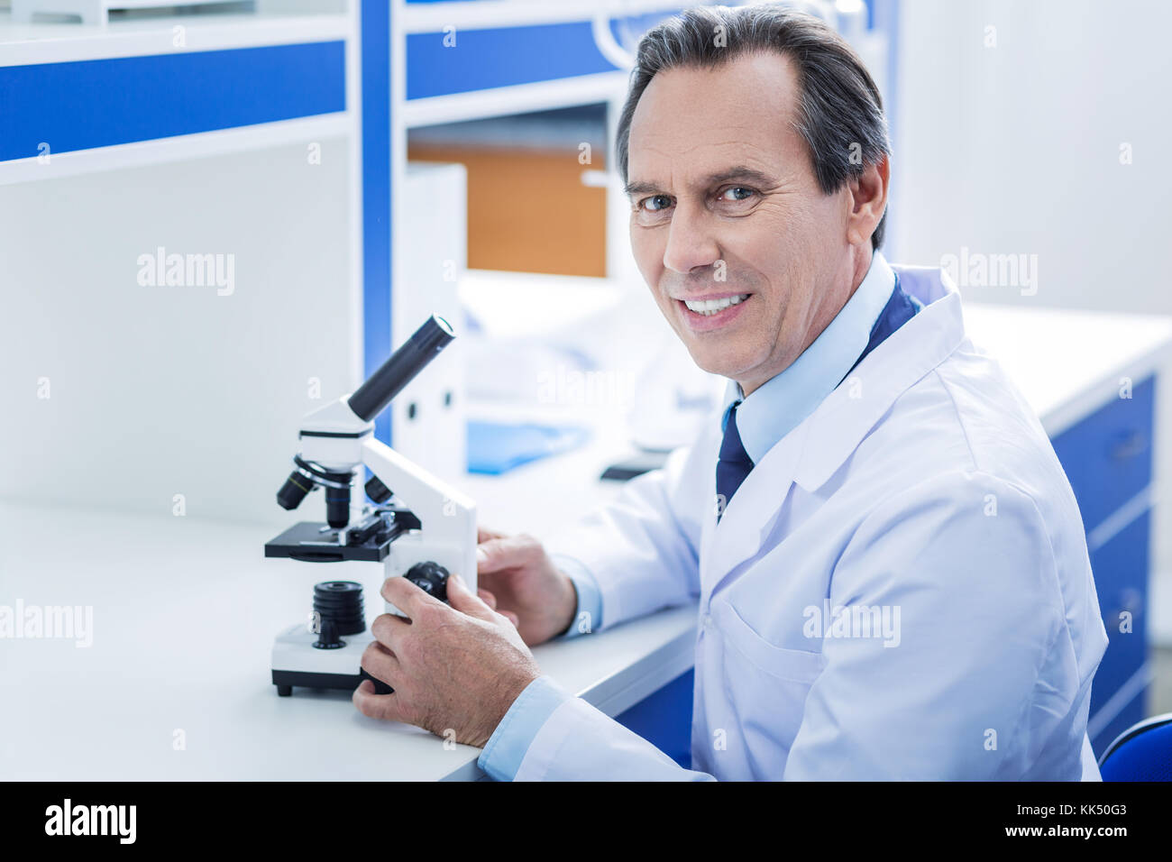 Positive experienced man working in the lab Stock Photo - Alamy