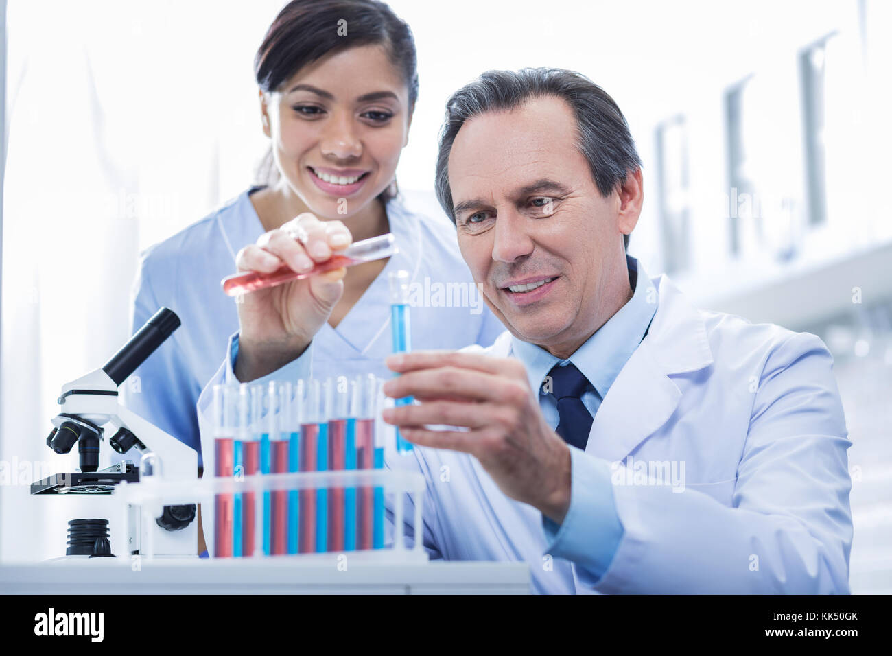 Smart experienced doctor holding test tubes Stock Photo - Alamy