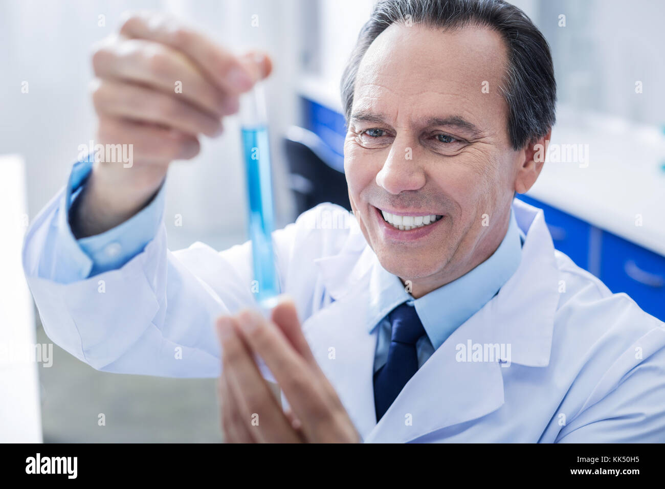 Cheerful positive man looking at the test tube Stock Photo - Alamy Cheerful positive man looking at the test tube Stock Photo - Alamy