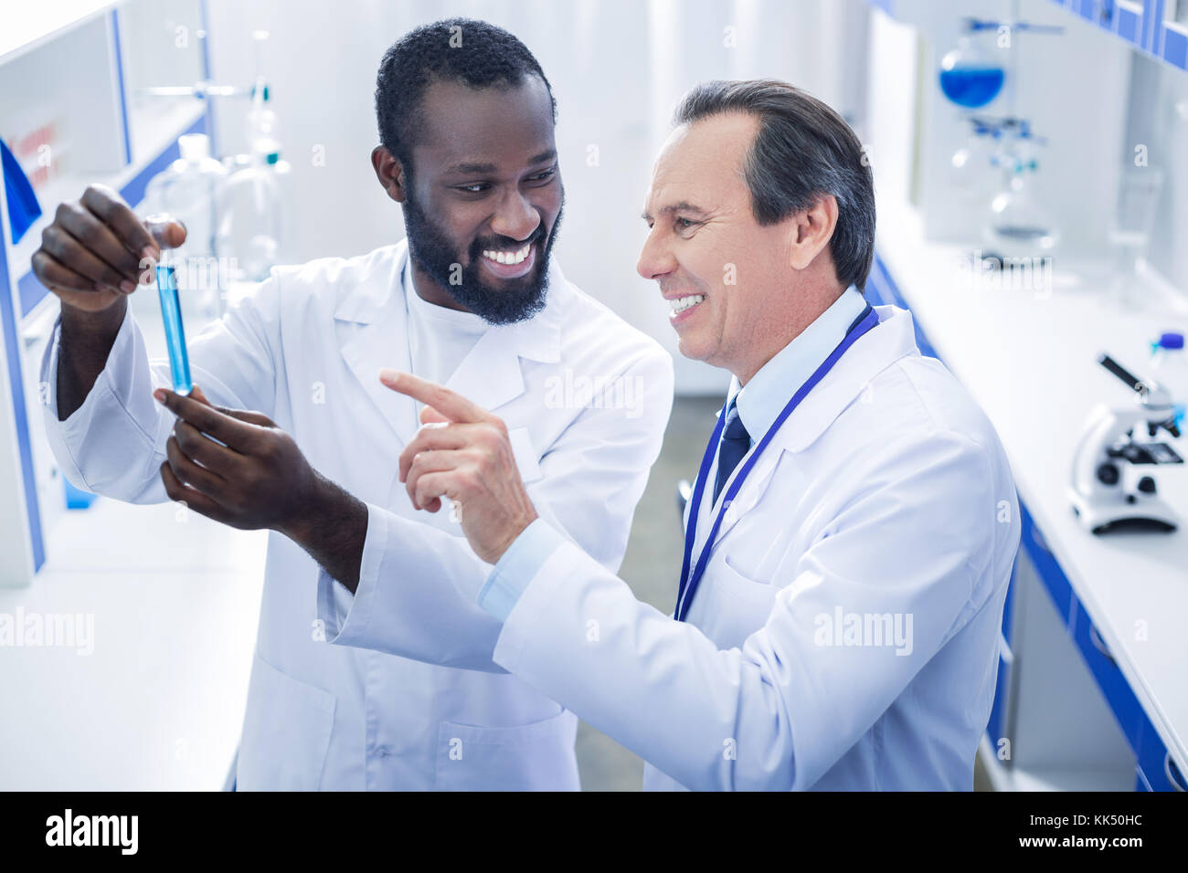 Happy cheerful man pointing at the test tube Stock Photo - Alamy