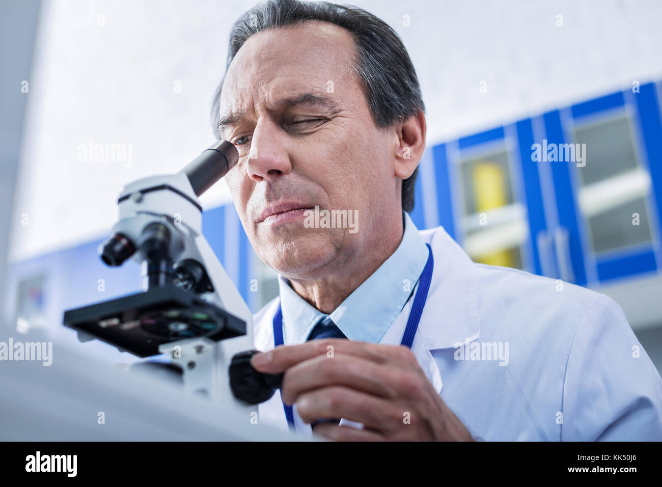 Serious professional scientist looking into the microscope Stock Photo ...