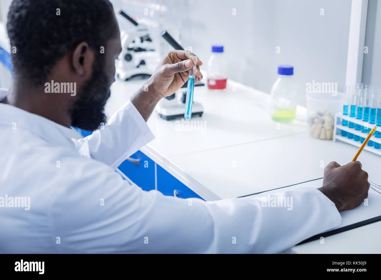 Nice smart doctor holding the vaccine Stock Photo - Alamy
