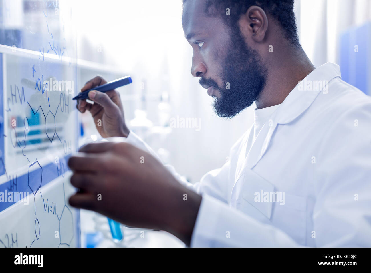 Serious male scientist writing a formula Stock Photo - Alamy