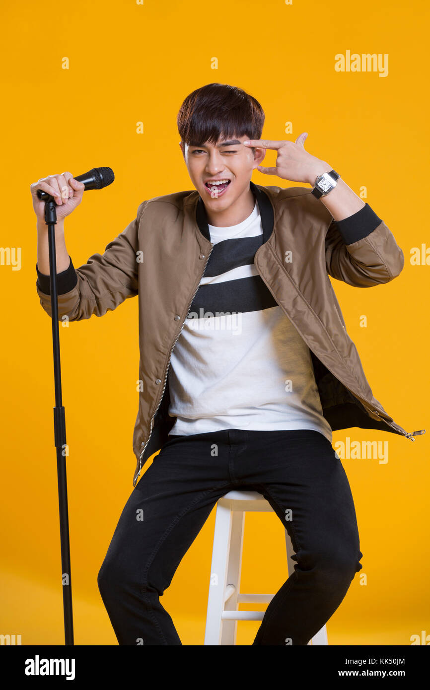 Cheerful young Chinese man singing with microphone Stock Photo - Alamy