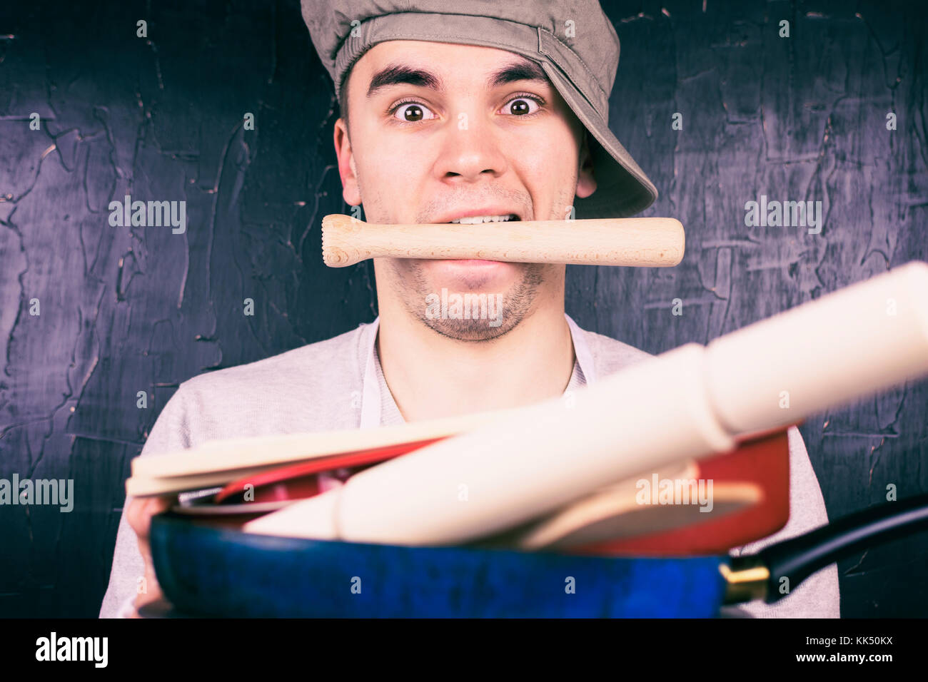 A young man holding different wooden utensils Stock Photo - Alamy