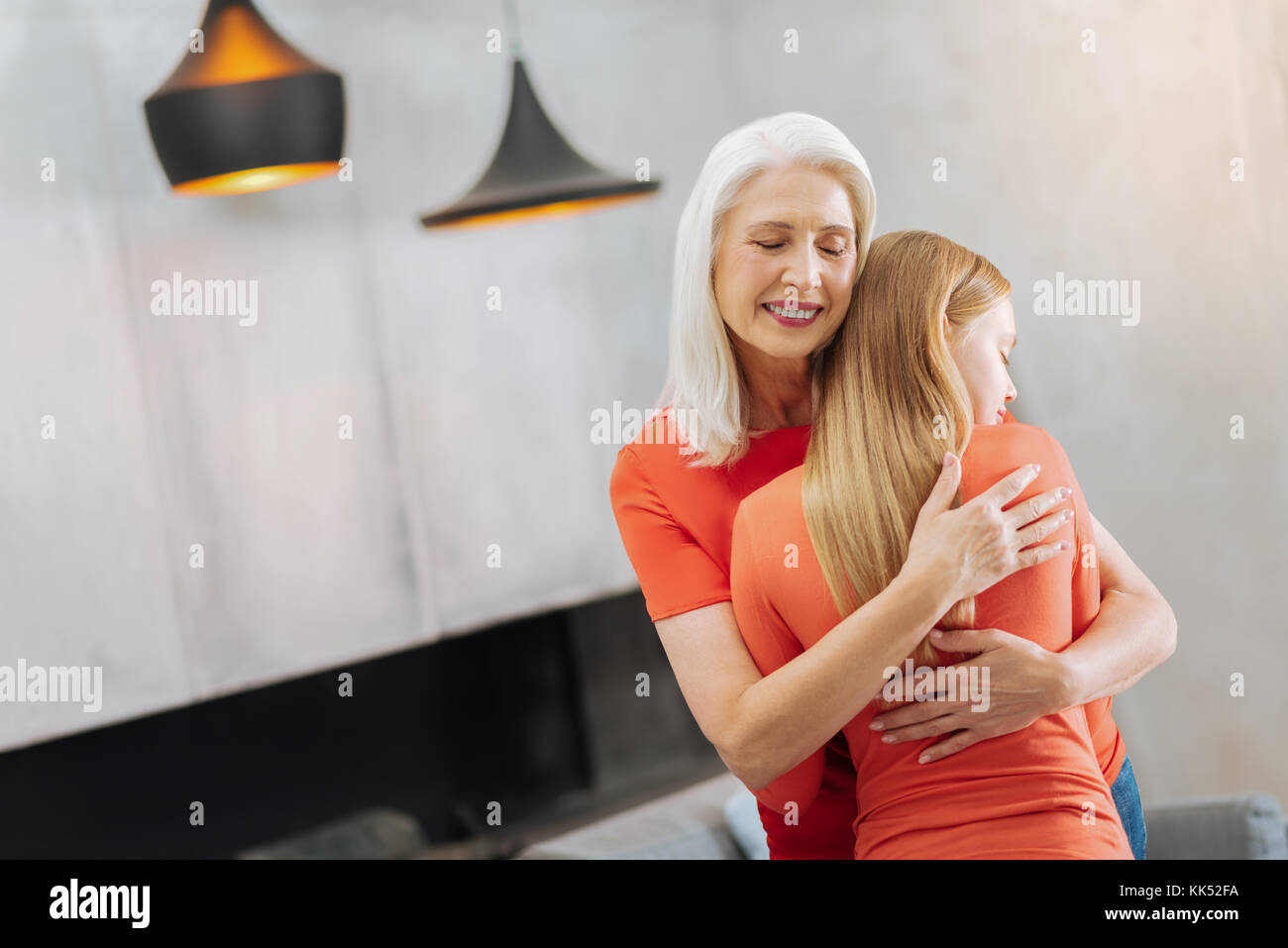 Warm hug. Pleasant happy age woman smiling and hugging her ...