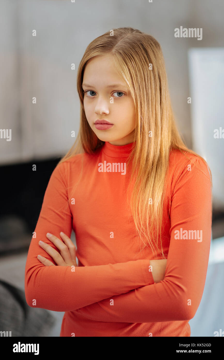 Cheerless mood. Unhappy nice serious girl standing cross handed and ...