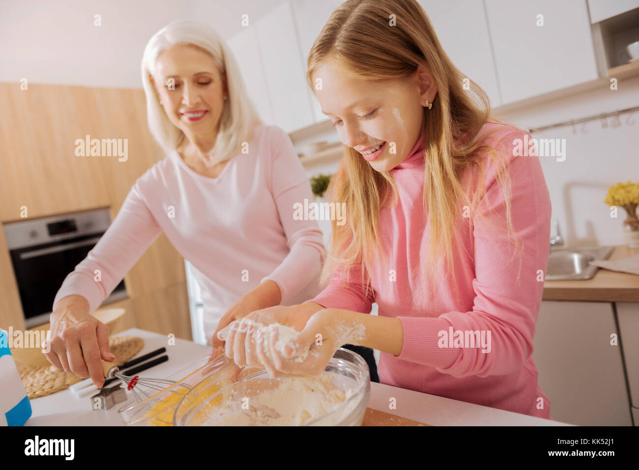 Food preparation. Delighted positive cute girl smiling and looking at ...