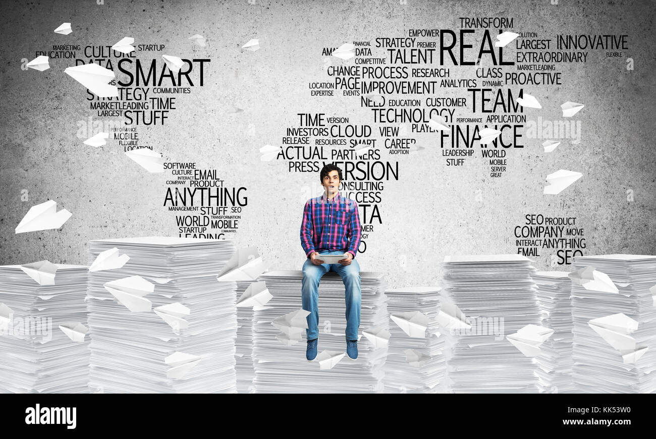 Attractive man sitting on pile of paper documents Stock Photo - Alamy