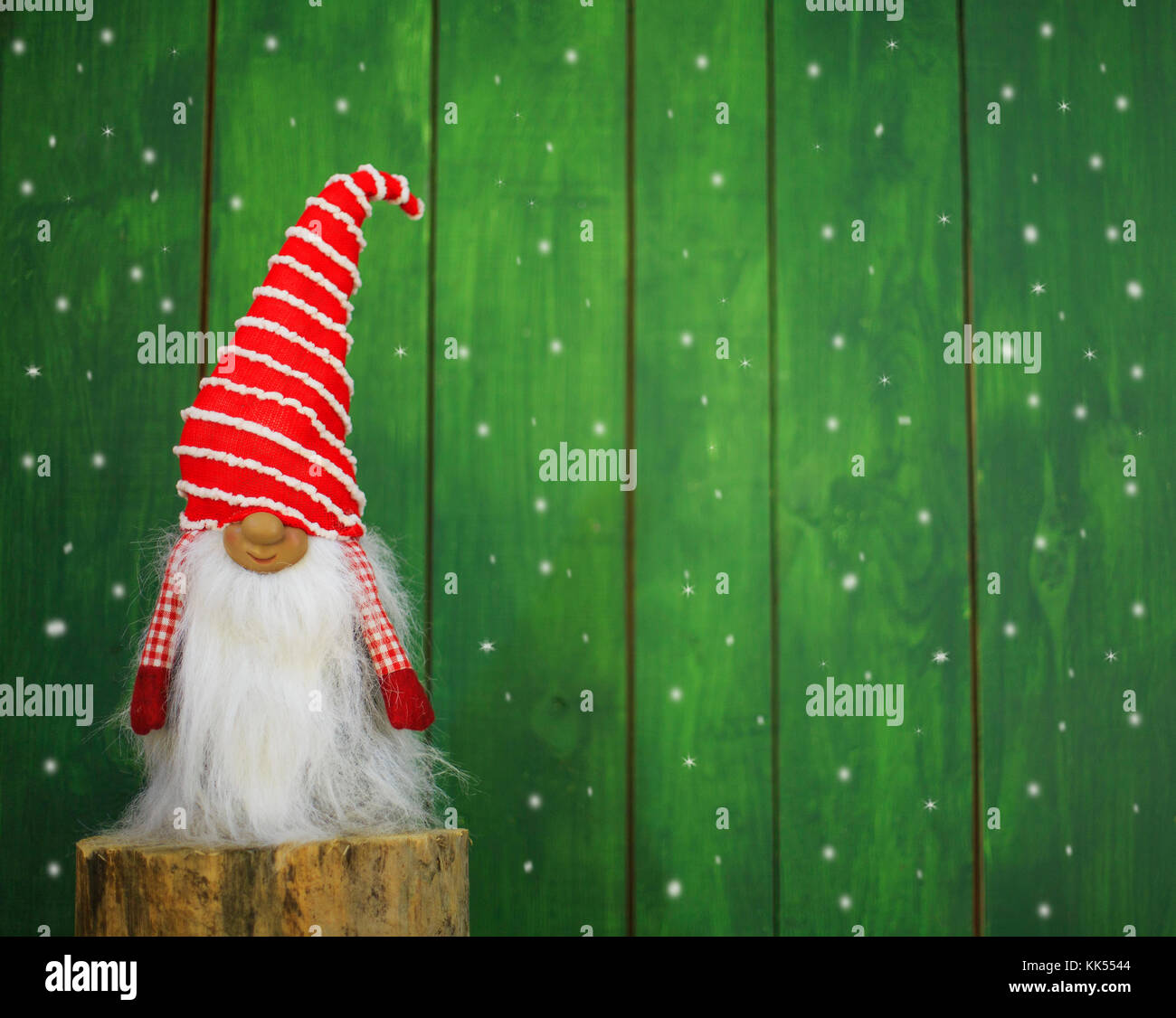 Closeup the gnome, standing on a stump with a twisted hat and a long ...