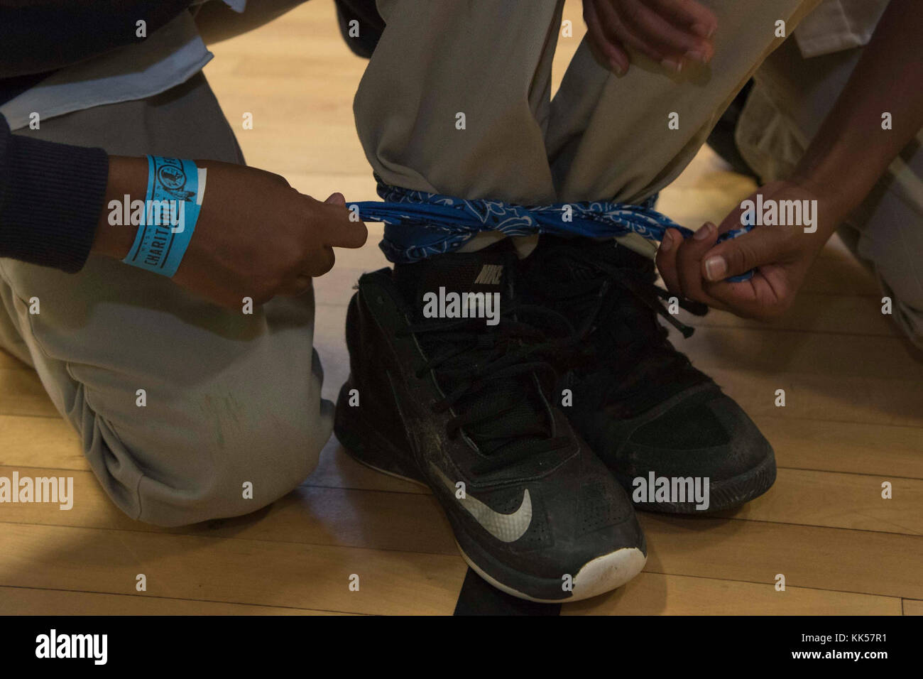 Participants tie their ankles together for a three-legged race during ...