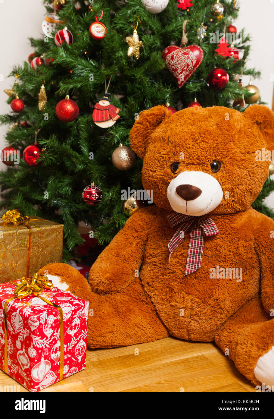 Teddy bear near christmas tree with gifts Stock Photo - Alamy