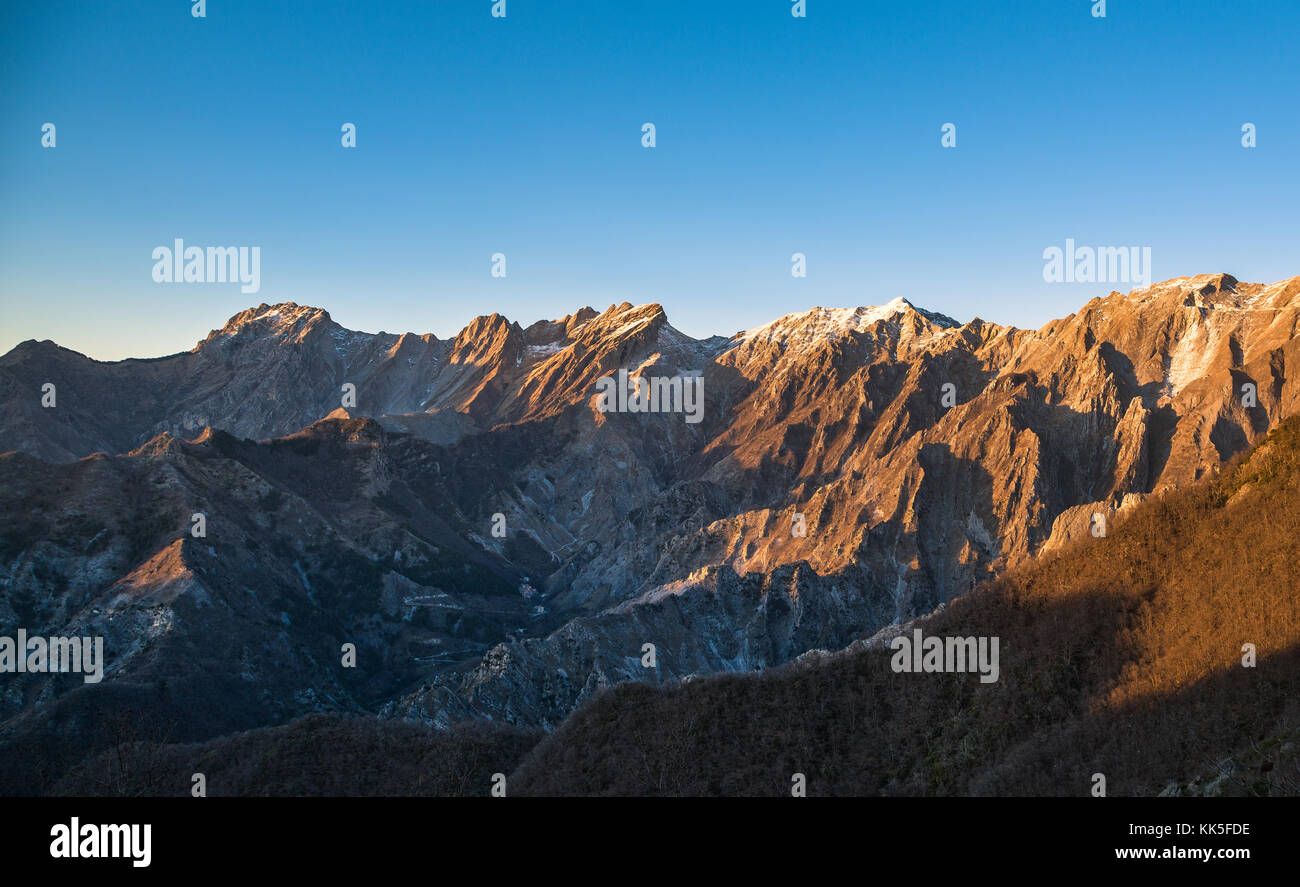 Apuane alpi or Apuan alps snowy mountains and marble quarry at sunset ...