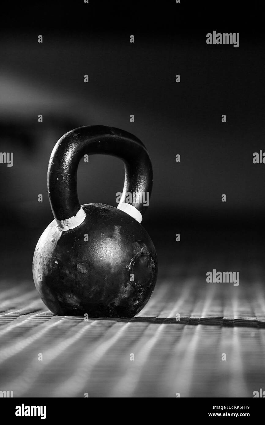 Close up view of a kettlebell on the floor in a dark gym with edgy ...