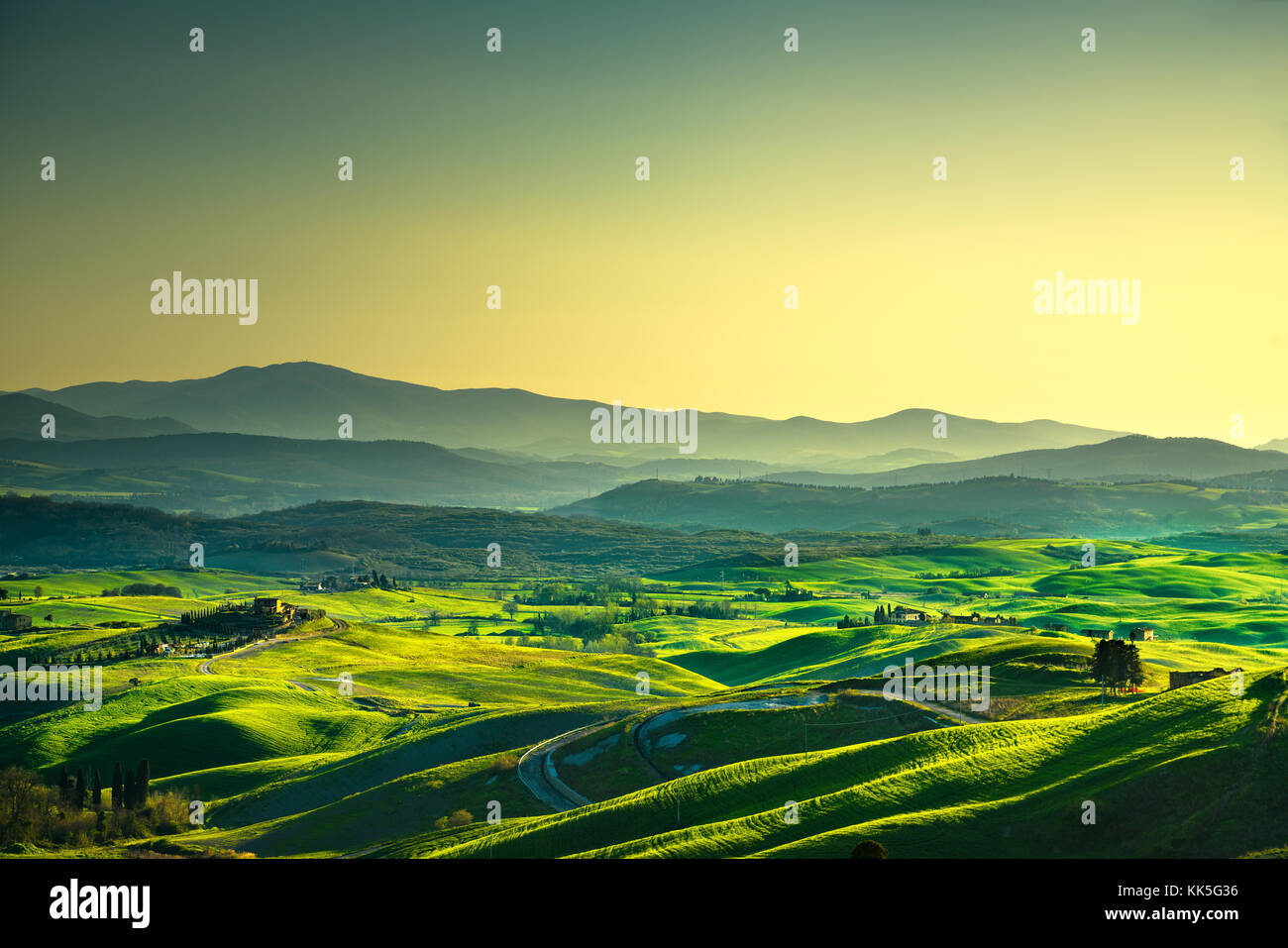 Volterra panorama, rolling hills, trees, and green fields at sunset ...