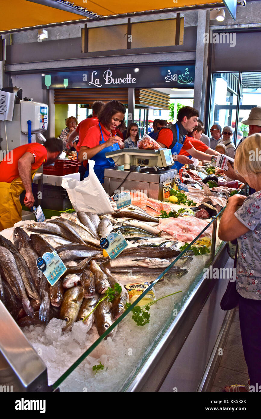 French families buying fresh seafood at a busy market stall in the ...