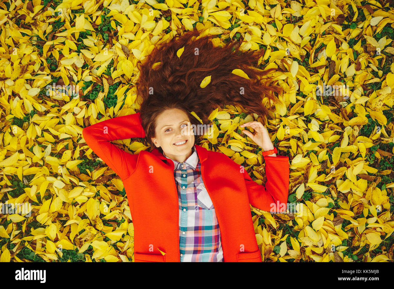 Young beautiful lady surrounded autumn leaves Stock Photo - Alamy