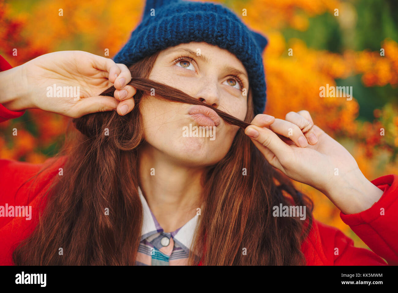 Beautiful girl showing mustache from her hair Stock Photo - Alamy