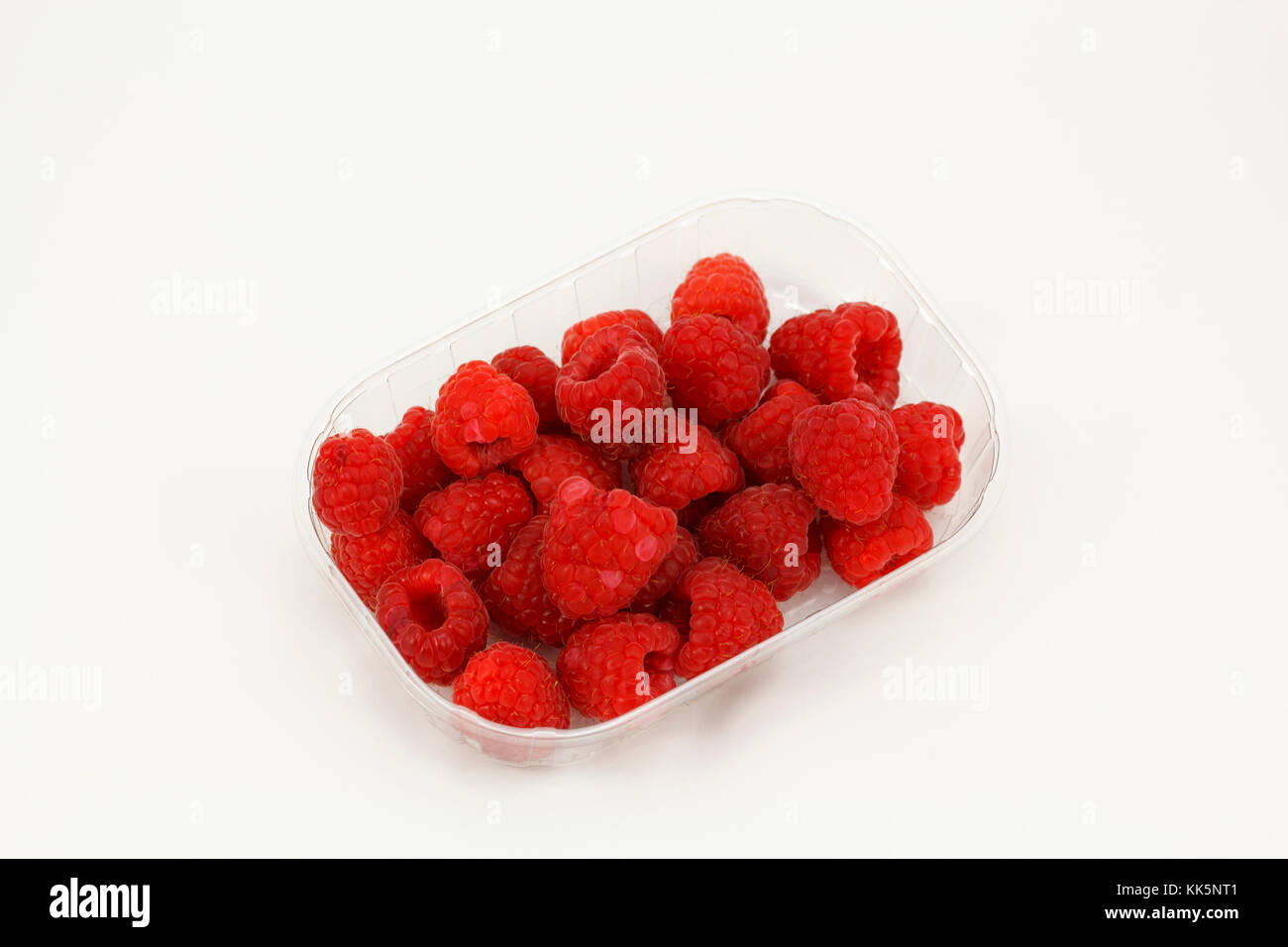 Raspberries in a plastic box, isolated in a white background Stock ...