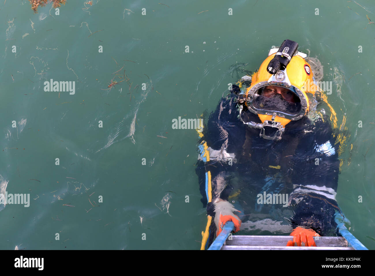 A diver with a local salvage team floats in the water while working to ...