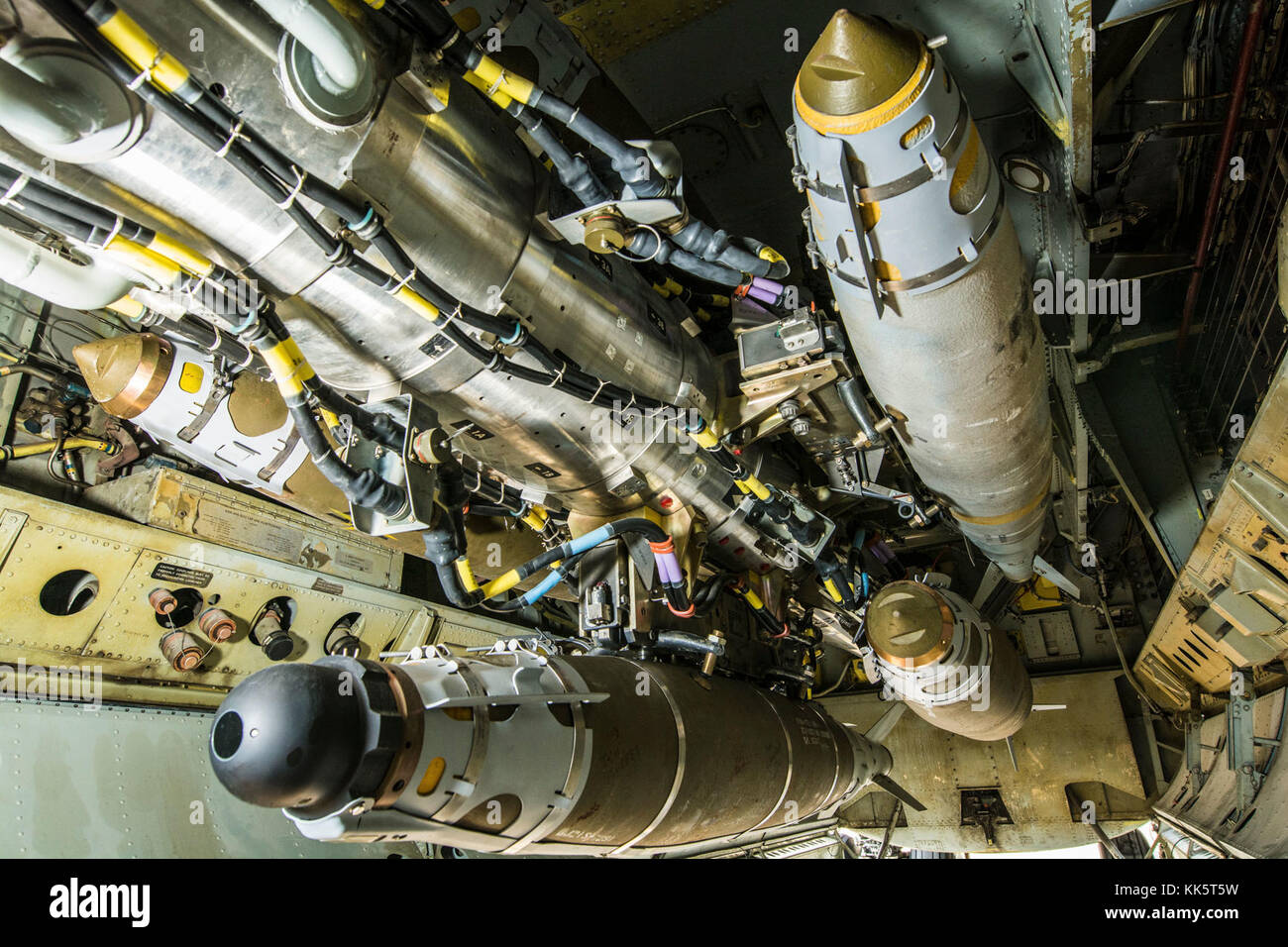 A U.S. B-52 Bomber sits on a flightline with munitions loaded on a ...