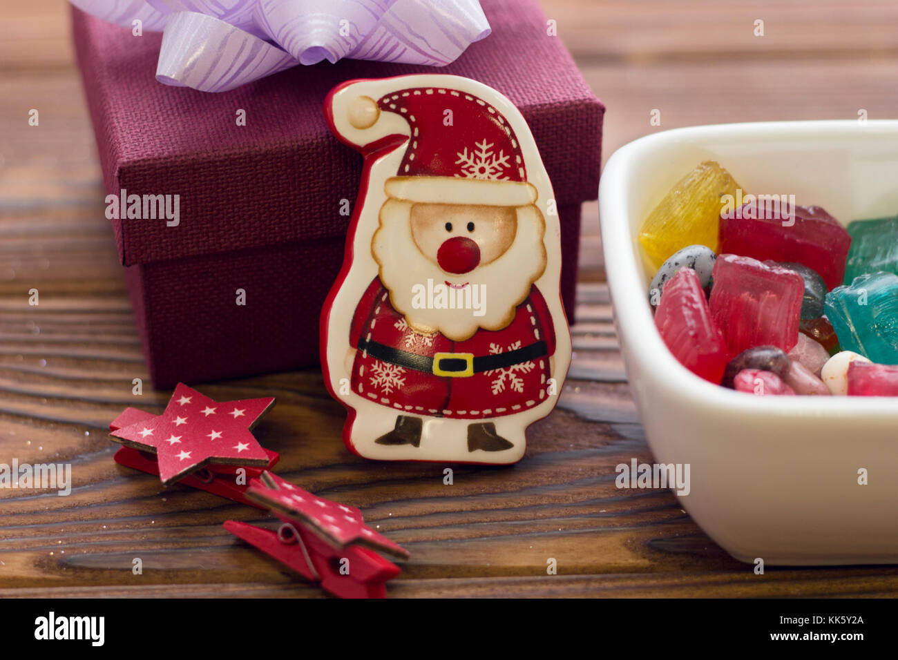 A toy santa, a bowl of candies and a gift box Stock Photo - Alamy