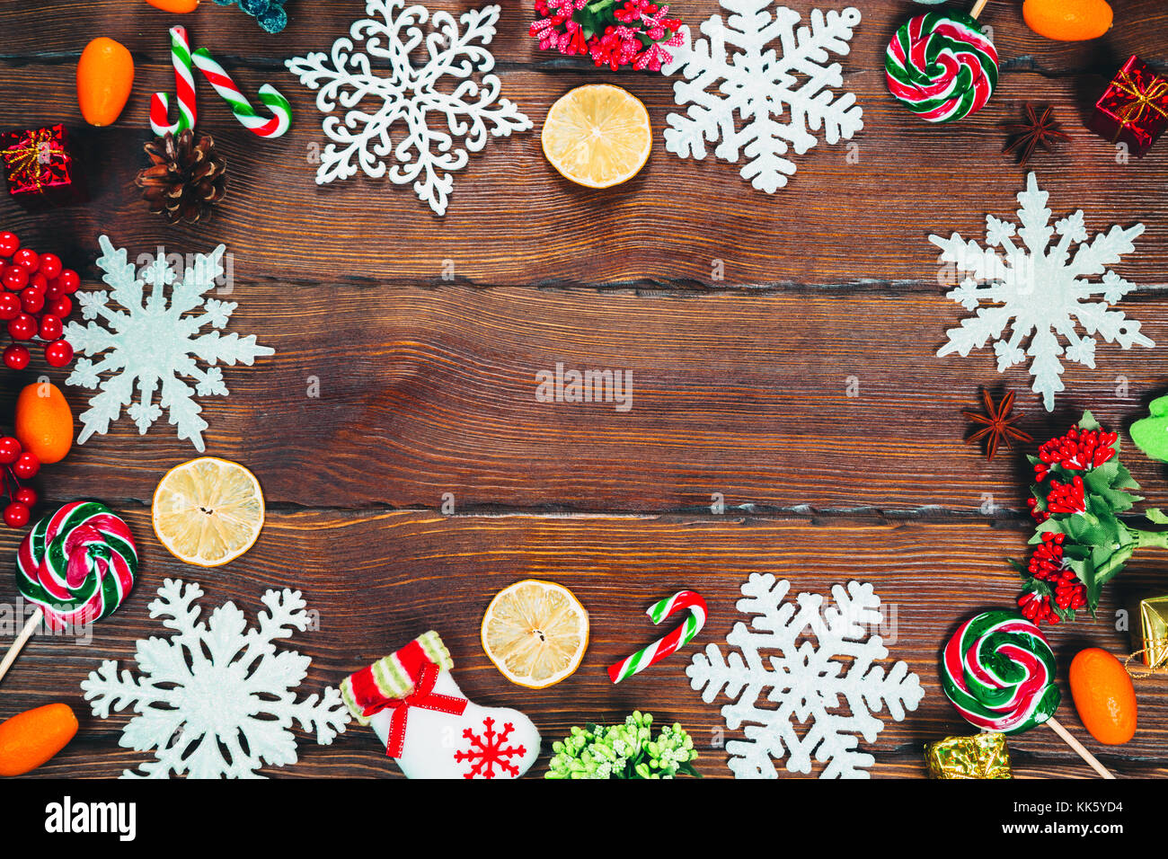 Christmas background with snowflakes, cones, candy, dried oranges and ...