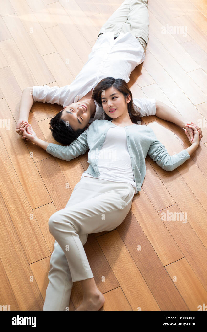 Young Chinese couple resting on wooden floor Stock Photo - Alamy