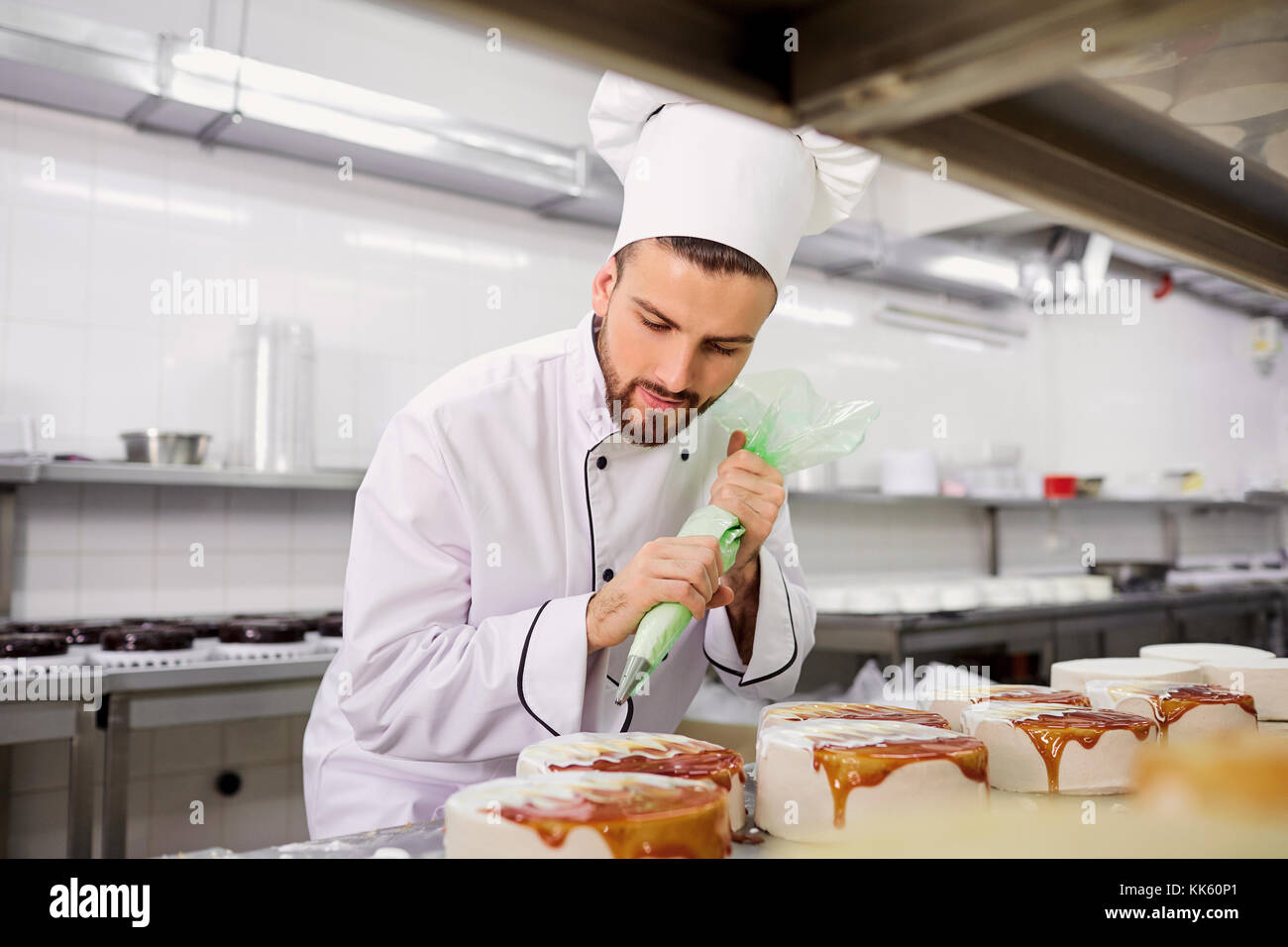 The confectioner is preparing a cake in the kitchen of the pastr Stock ...