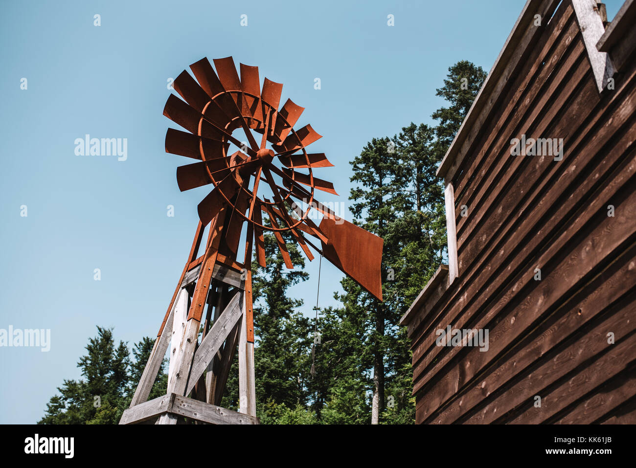 Old rusty windmill with blue sky in background Stock Photo - Alamy