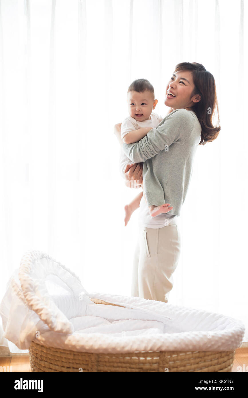 Happy Chinese mother and cute baby at home Stock Photo - Alamy