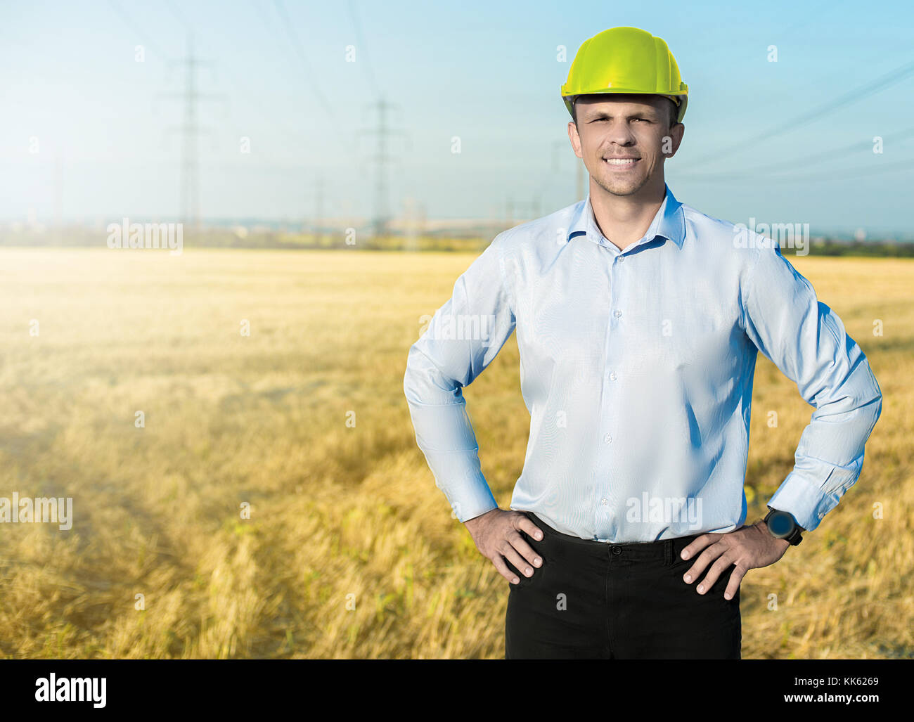 Young blue collar worker or engineer wearing in yellow helmet stands in ...