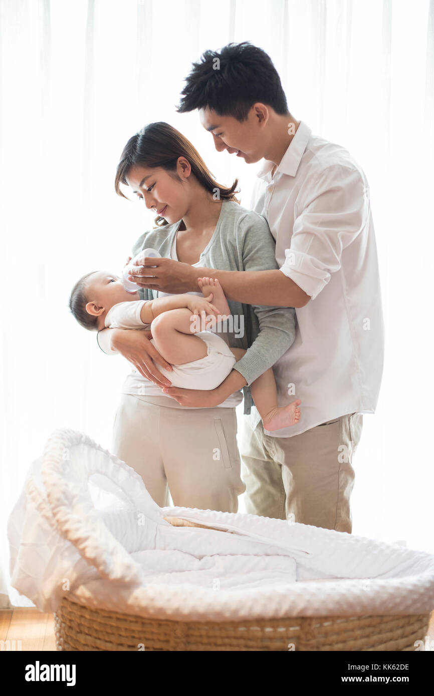 Young Chinese parents feeding baby Stock Photo - Alamy