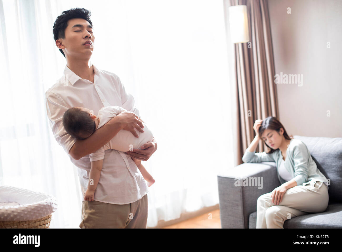 Tired Chinese father holding his sleeping baby Stock Photo - Alamy