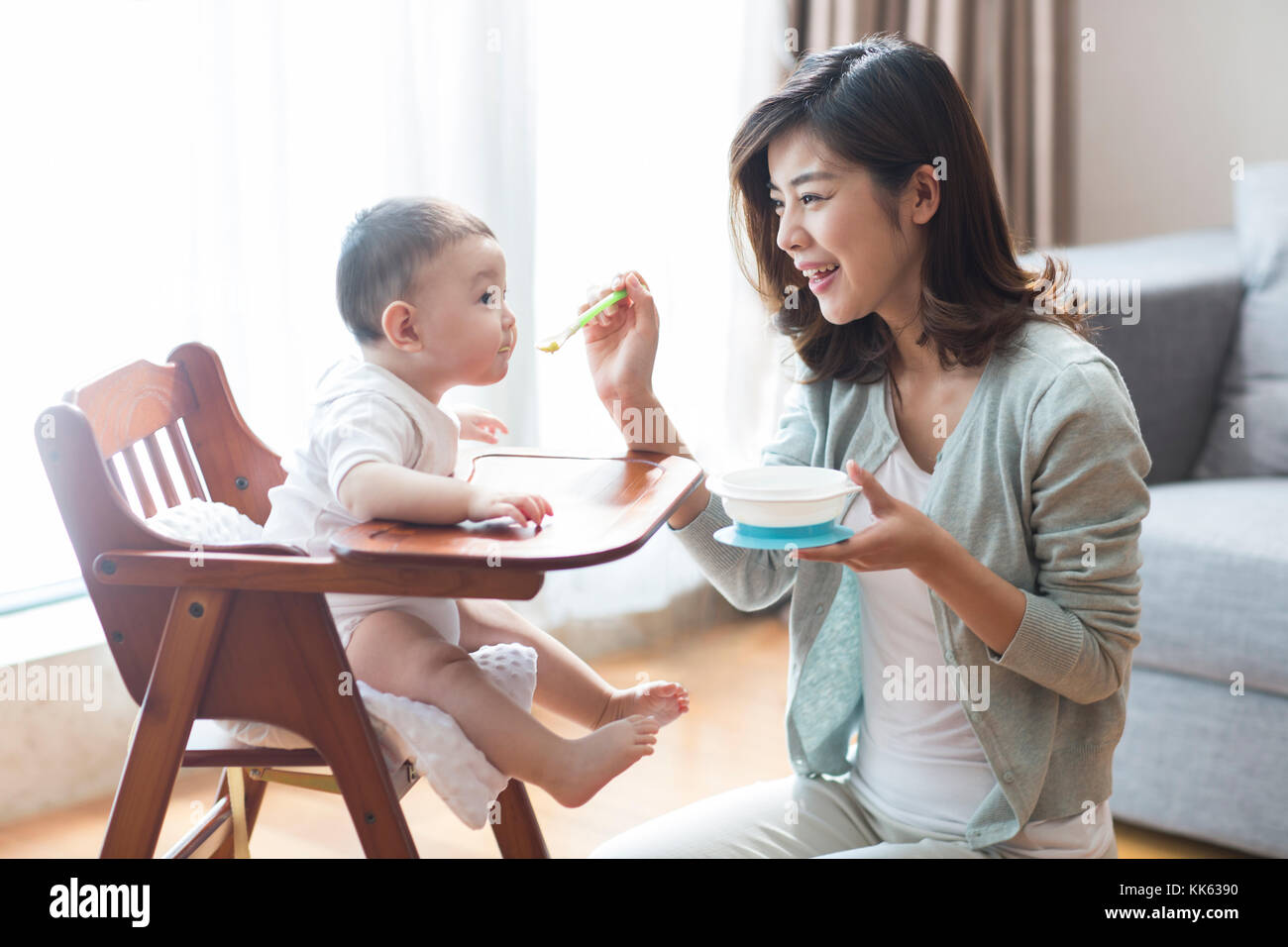Young Chinese mother feeding baby Stock Photo - Alamy