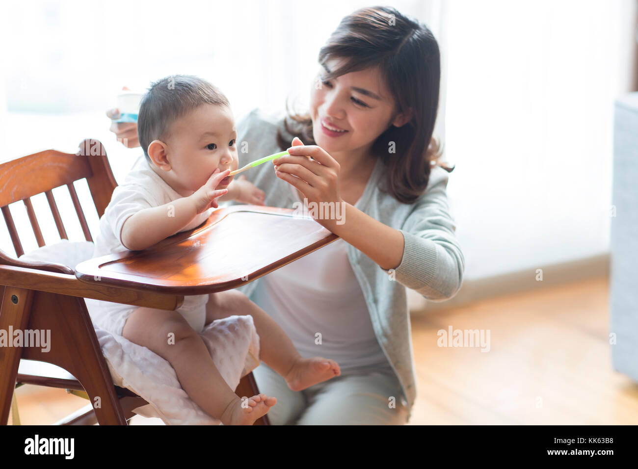 Young Chinese mother feeding baby Stock Photo - Alamy