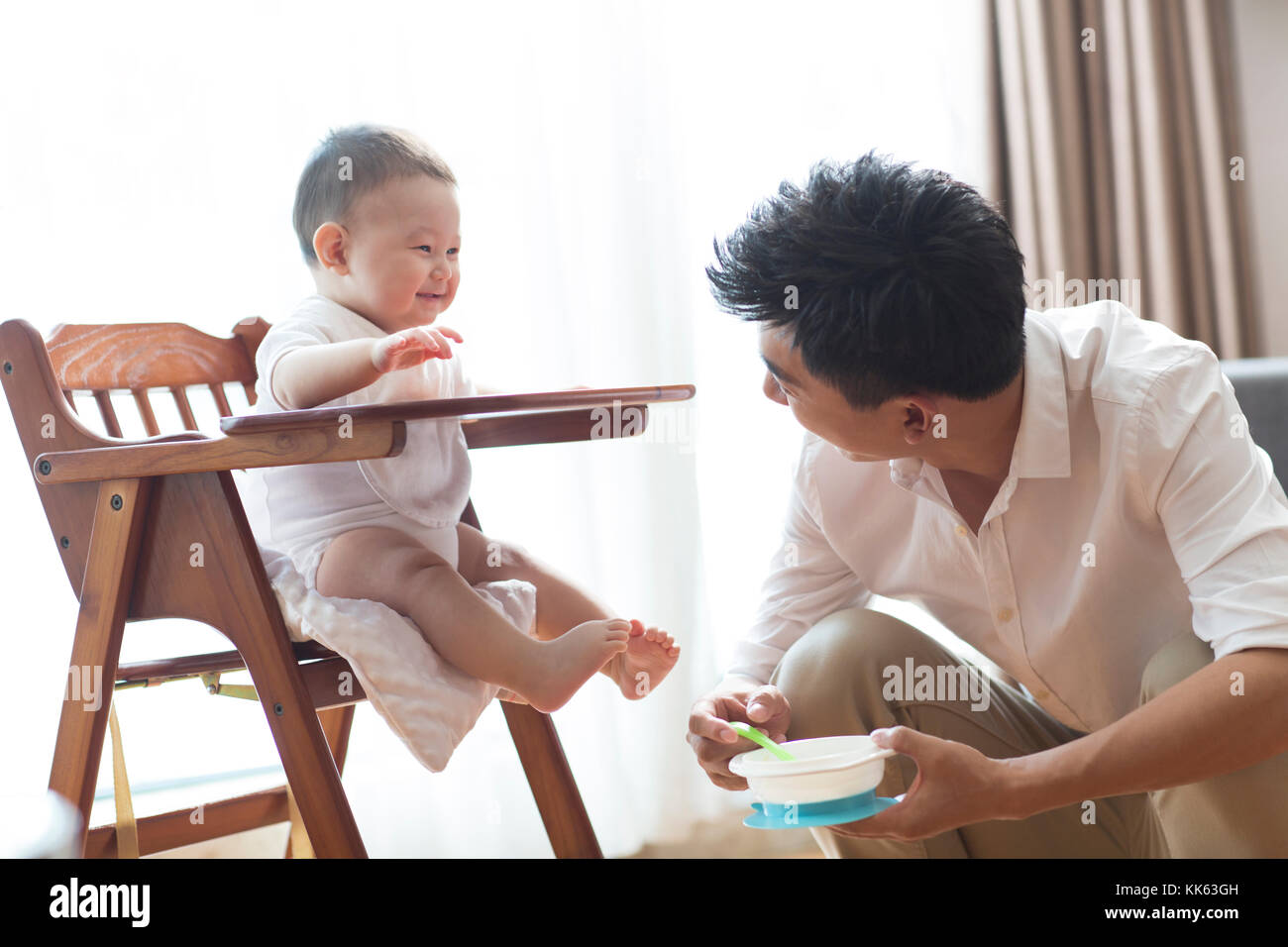 Young Chinese father feeding baby Stock Photo - Alamy