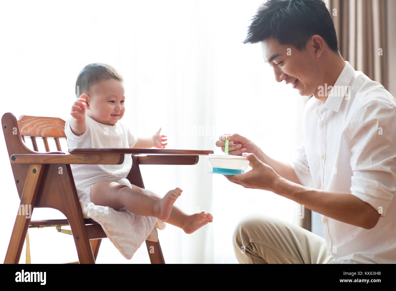 Young Chinese father feeding baby Stock Photo - Alamy
