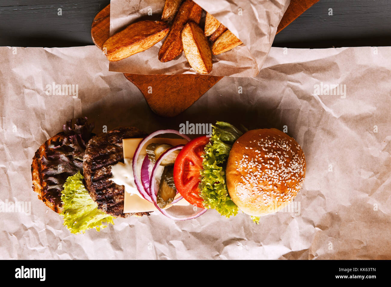 Burger decomposed into its components on kraft paper on a wooden table ...