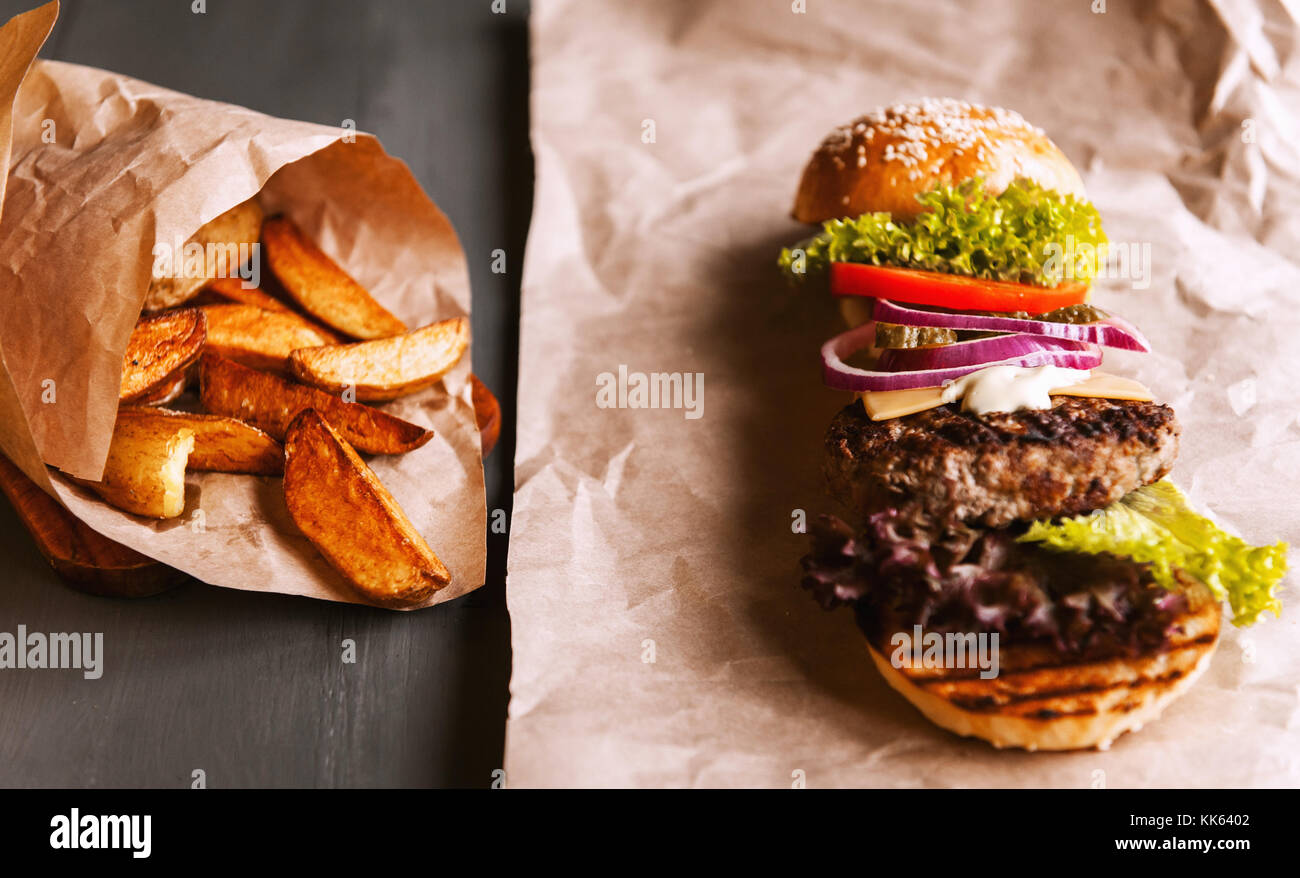 Burger decomposed into its components on kraft paper on a wooden table ...