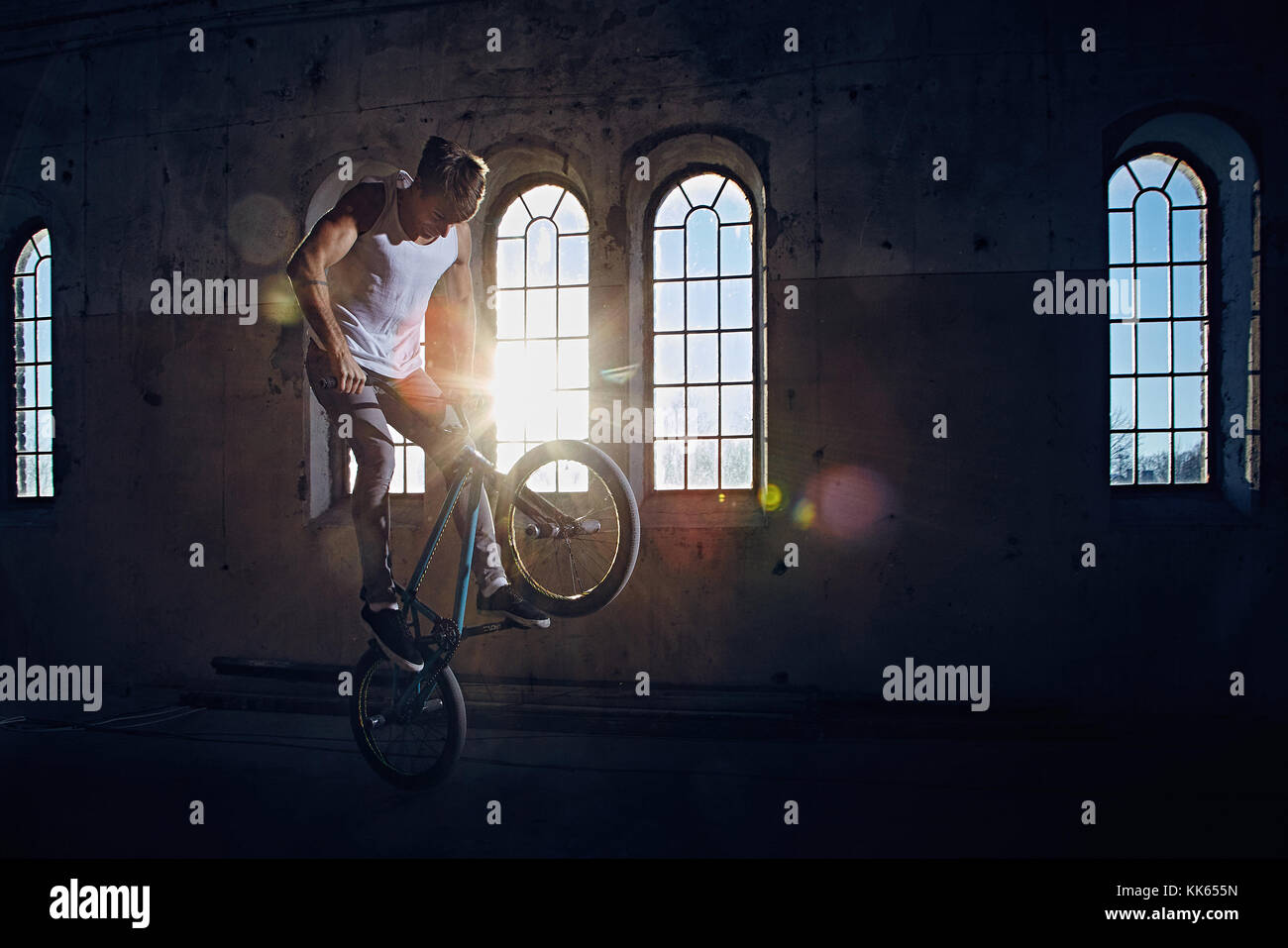 BMX stunt and jump riding in a hall with sunlight Stock Photo - Alamy
