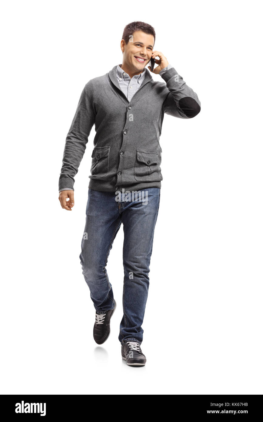 Full length portrait of a guy walking and talking on a phone isolated ...