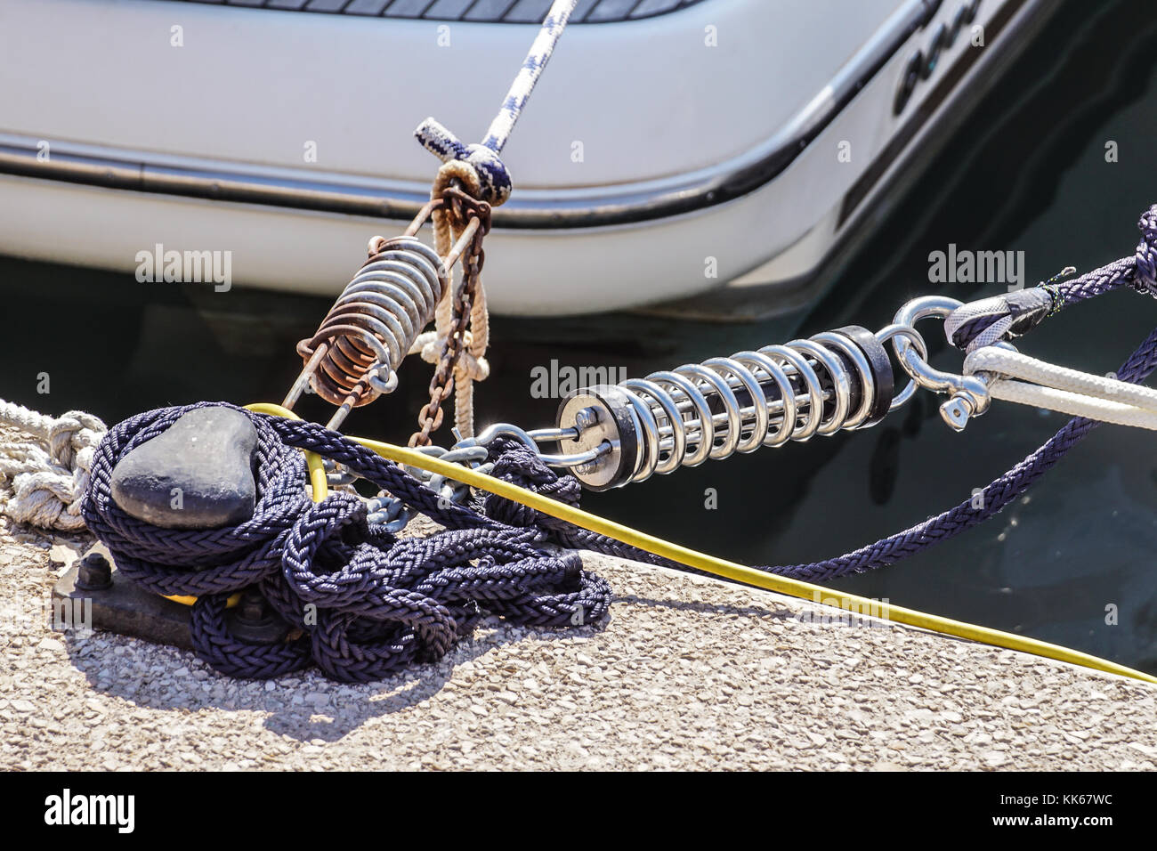 Metal cleat for mooring boats, bolted to the ground, with rope and ...