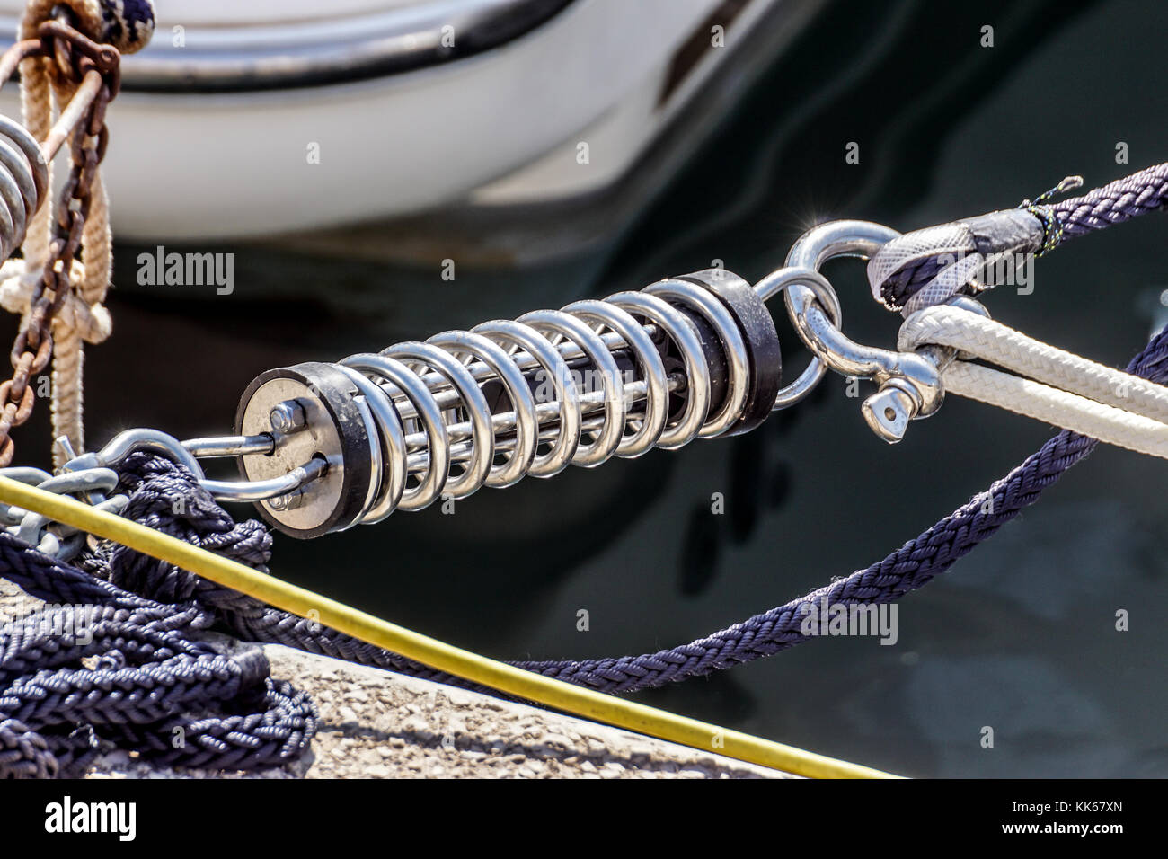 Metal cleat for mooring boats, bolted to the ground, with rope and ...