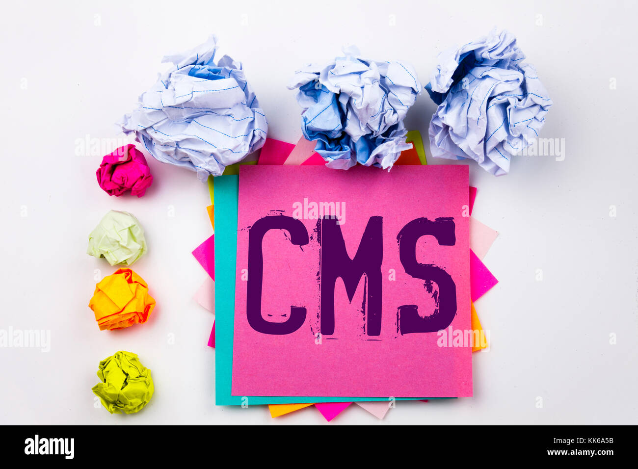 Writing text showing CMS written on sticky note in office with screw ...
