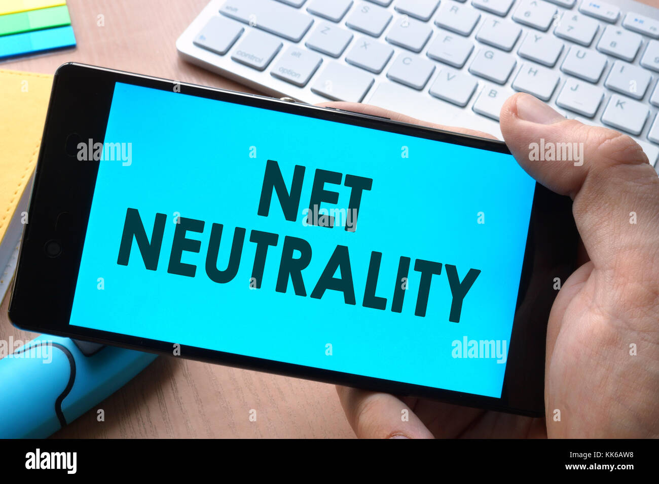 Man is holding smartphone with words net neutrality Stock Photo - Alamy