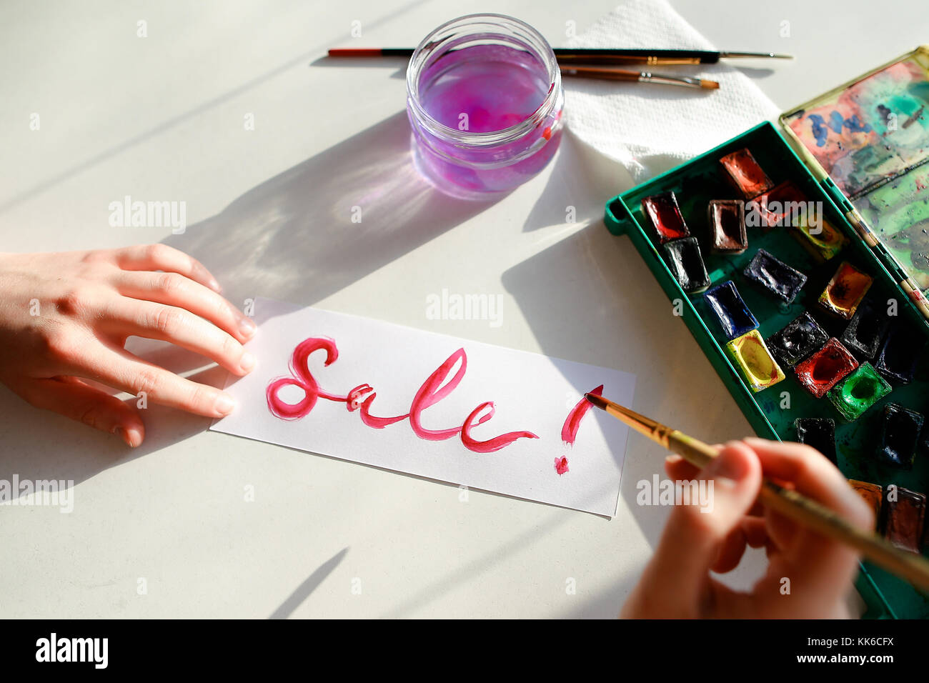 Girl painter writes with brush and paints inscription on sheet Stock ...