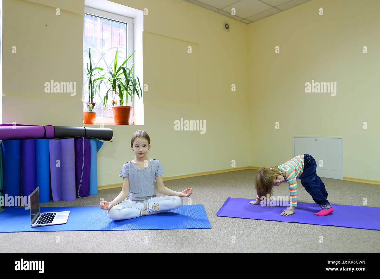 Little girl sits on floor in lotus position Stock Photo - Alamy